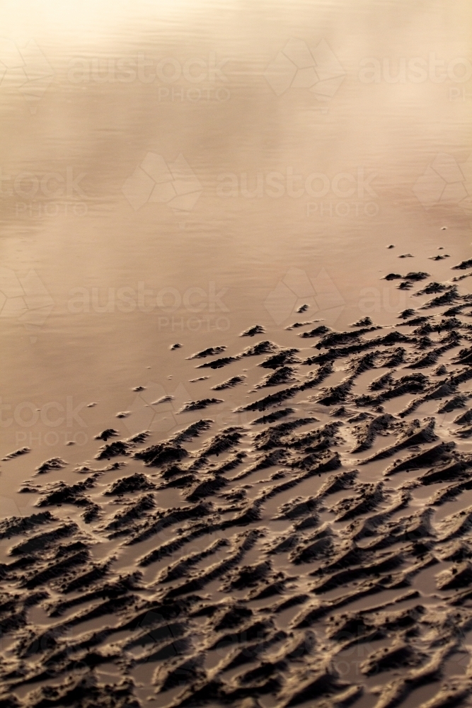 Image of Sand ripple patterns on a beach with water reflecting the sky ...