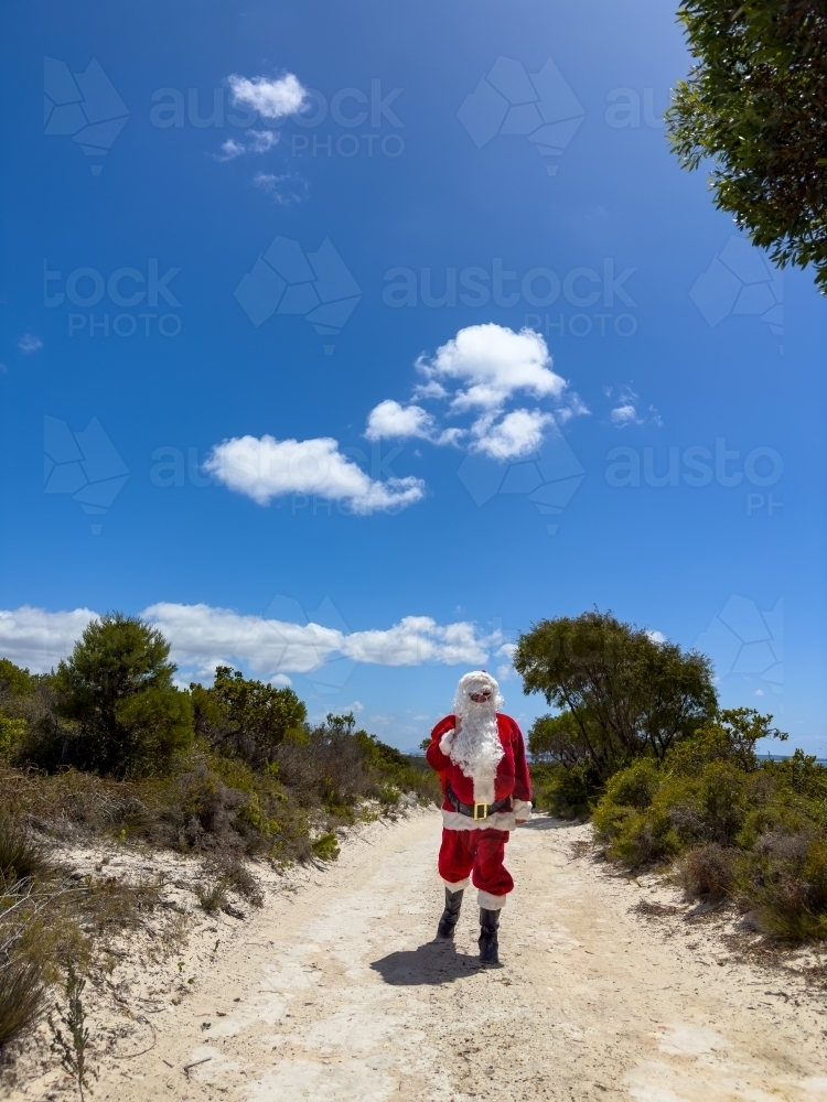 Image of santa in isolated landscape walking down a track through the ...