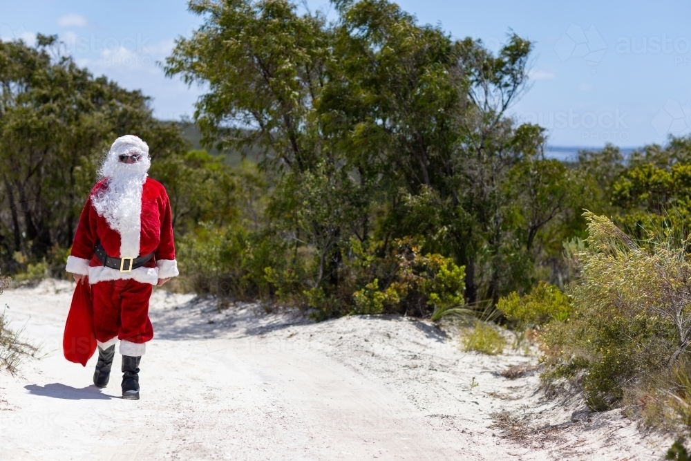 Image of Santa walking towards foreground along a sandy track in ...