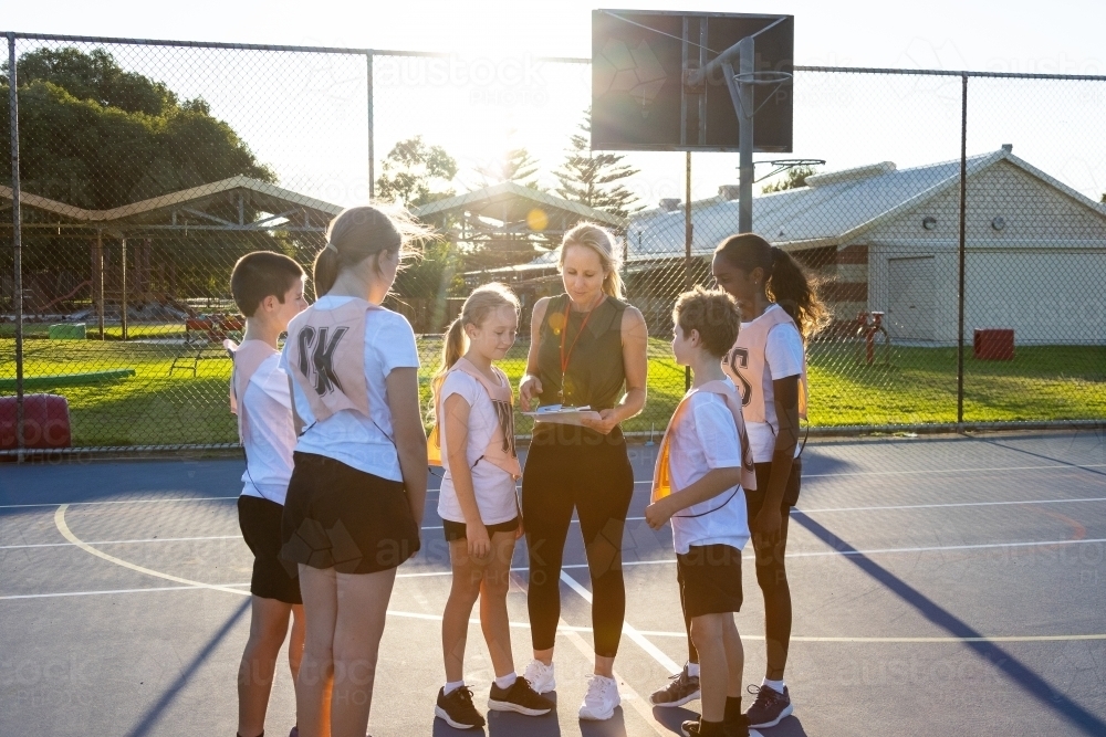 Image of school children at netball training with coach who is a mum ...