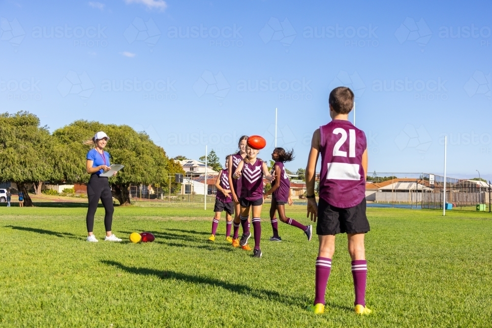 Image of schoolchildren practising handball drills at football training ...