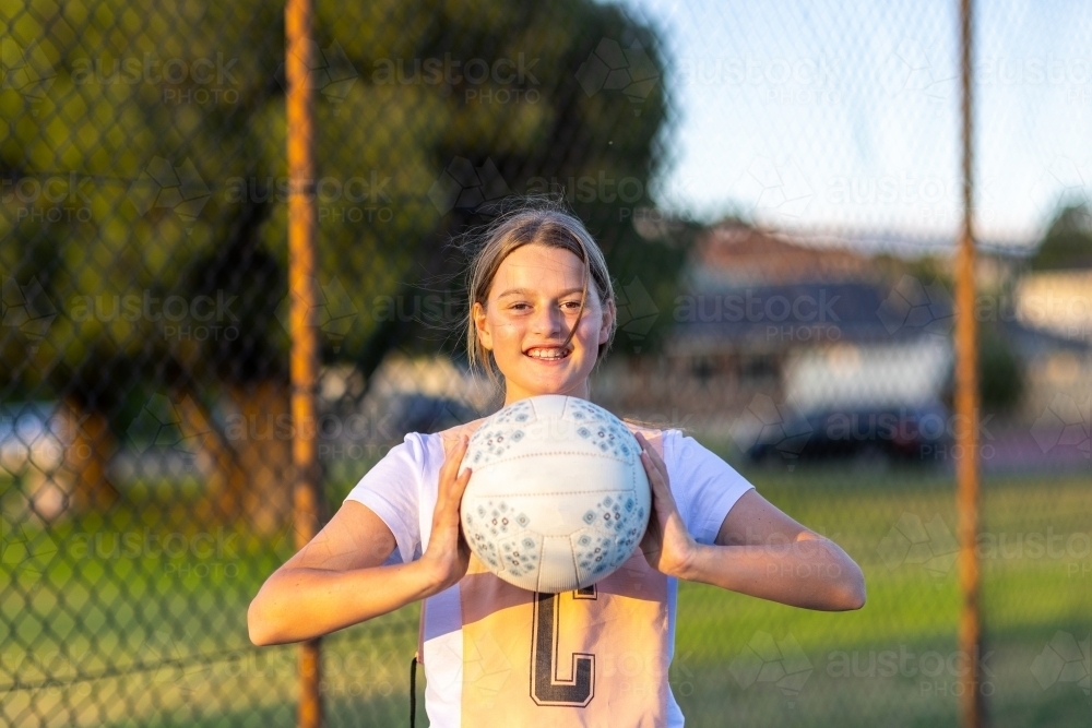 Image of schoolgirl holding netball in throwing position - Austockphoto
