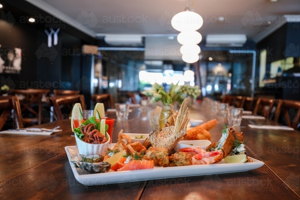 Image of Seafood platter in restaurant setting featuring squid, prawns ...