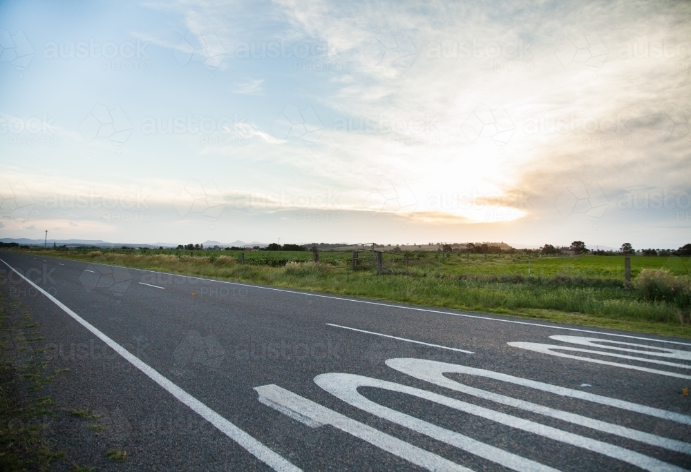 Image of Sealed rural road with 100 speed zone marking - Austockphoto