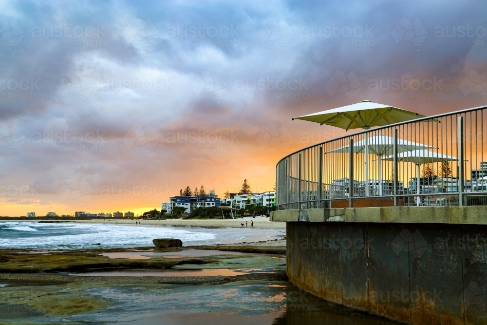 Image of Seaside pool under a dramatic sunset sky. - Austockphoto