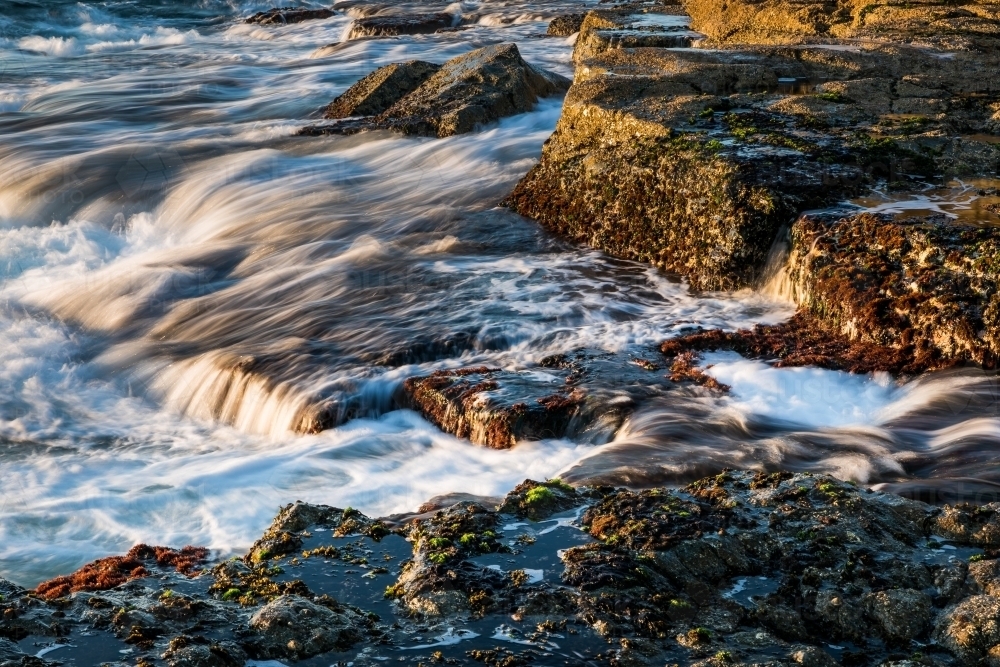 Image of seawater running across rocks - Austockphoto