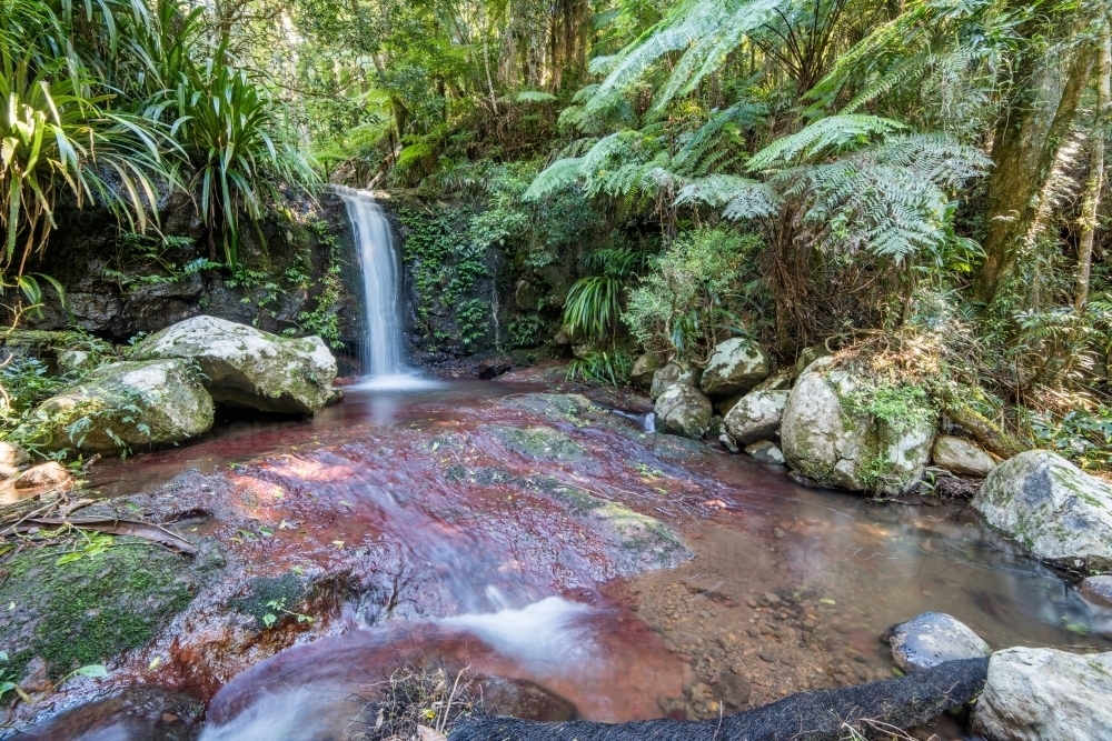 Image of Secluded area with small waterfall flowing - Austockphoto