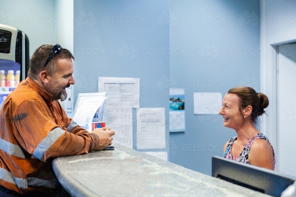 Image of Secretary and client speaking over counter at small business ...