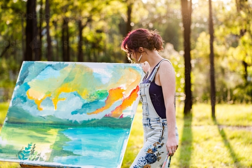 Image of Self taught young artist looking at beginning of artwork ...