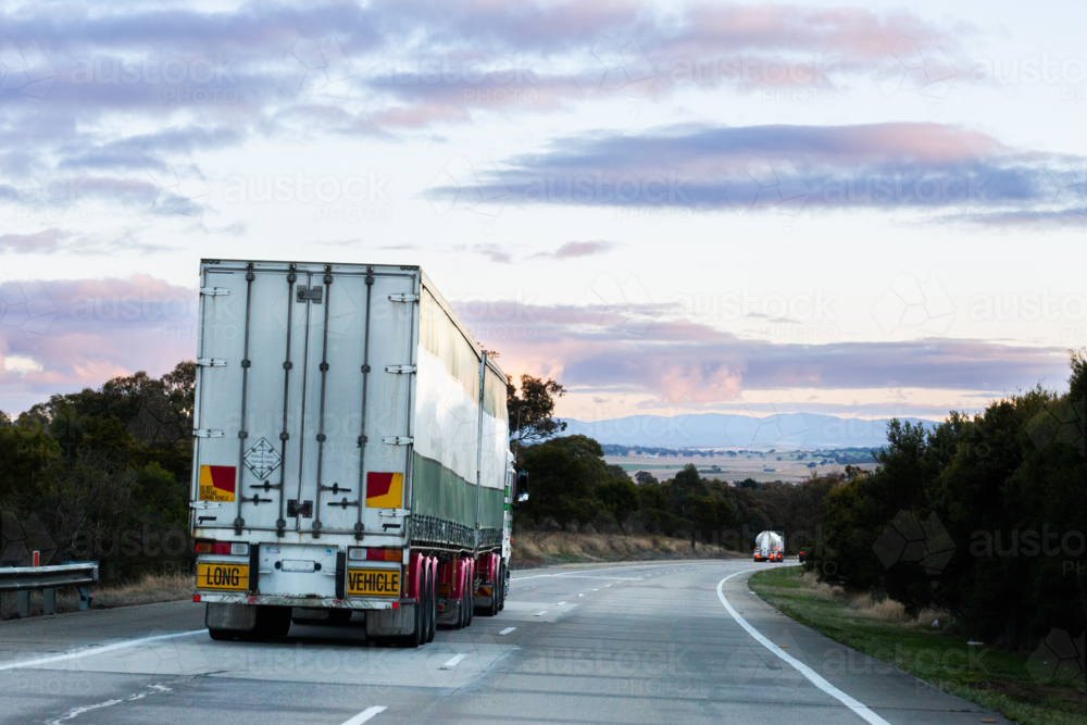 Image of Semi trailer truck transporting goods down rural highway in ...