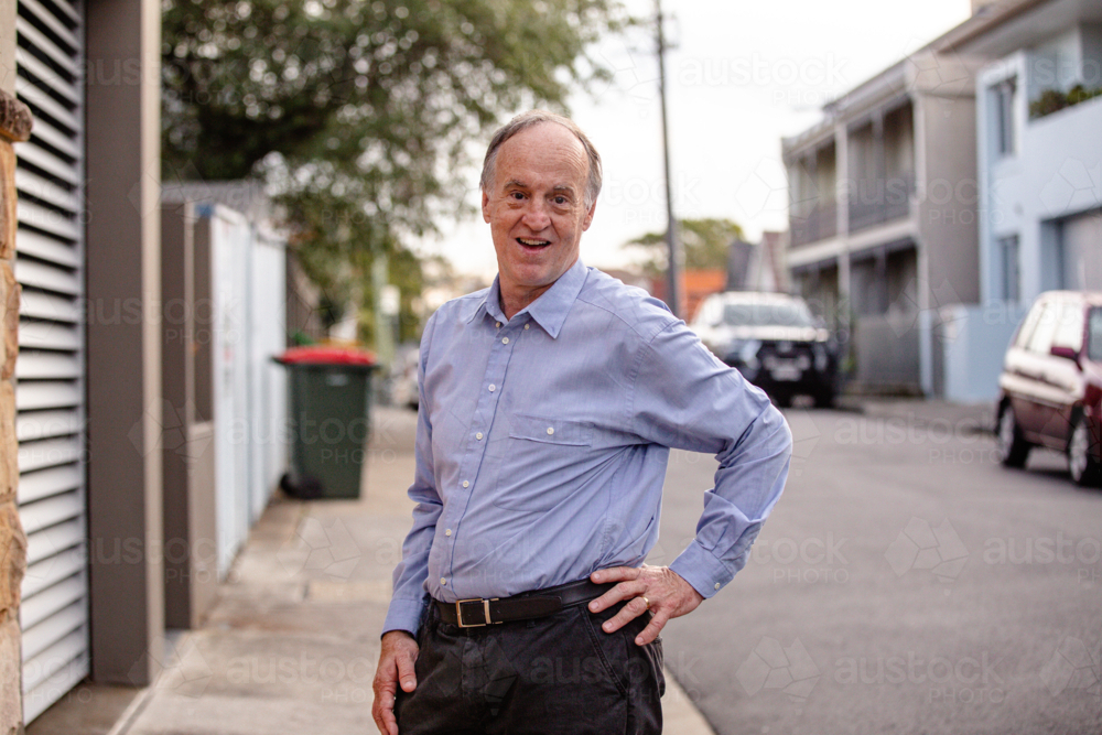 Image of Senior man standing on the residential sidewalk. - Austockphoto