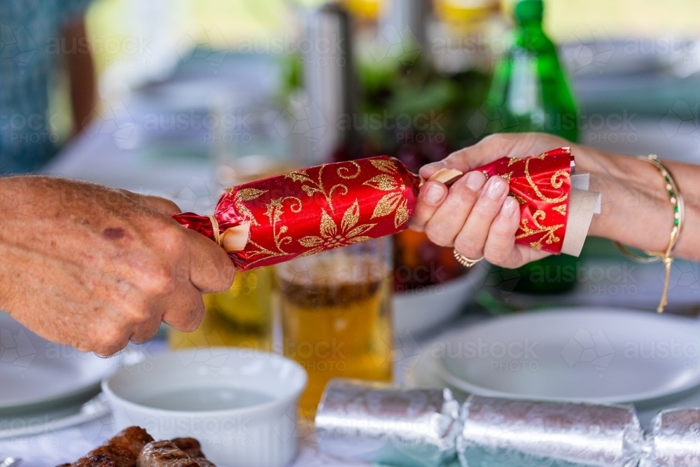 Image of Senior peoples hands holding Christmas cracker at lunch time ...