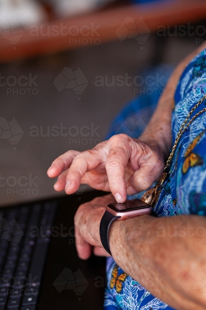 Image of senior person using smartwatch technology - Austockphoto