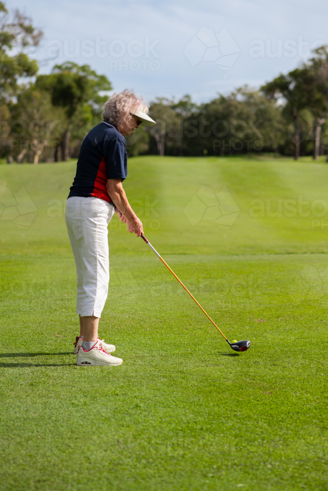 Image of senior woman playing golf - Austockphoto