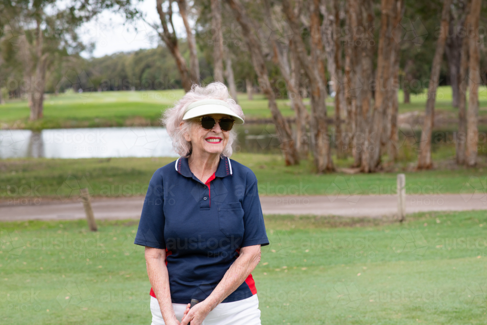 Image of senior woman playing golf - Austockphoto