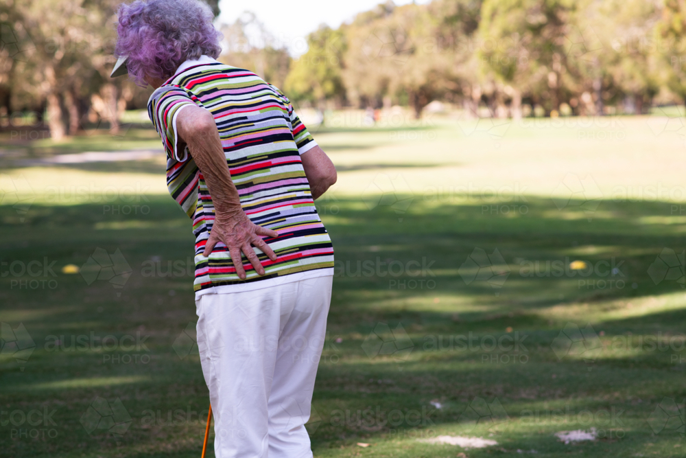 Image of senior woman with a sore back during golf - Austockphoto