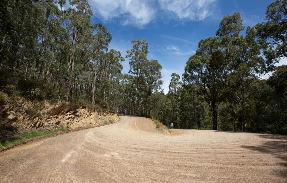 Image of Sharp bend on unsealed mountain road - Austockphoto