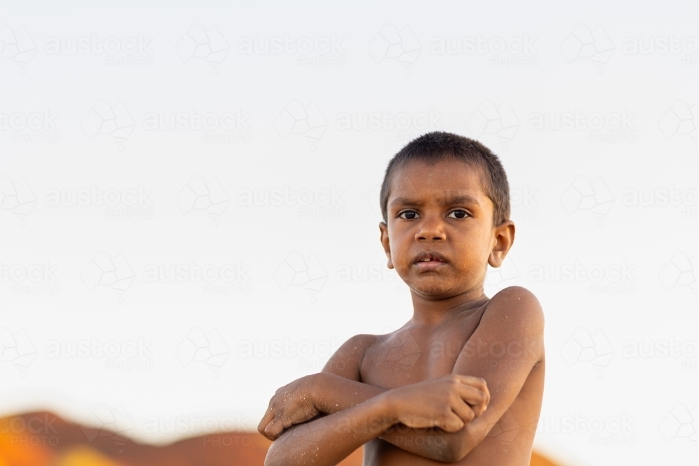Image of shirtless young aboriginal boy with sand on his skin against ...