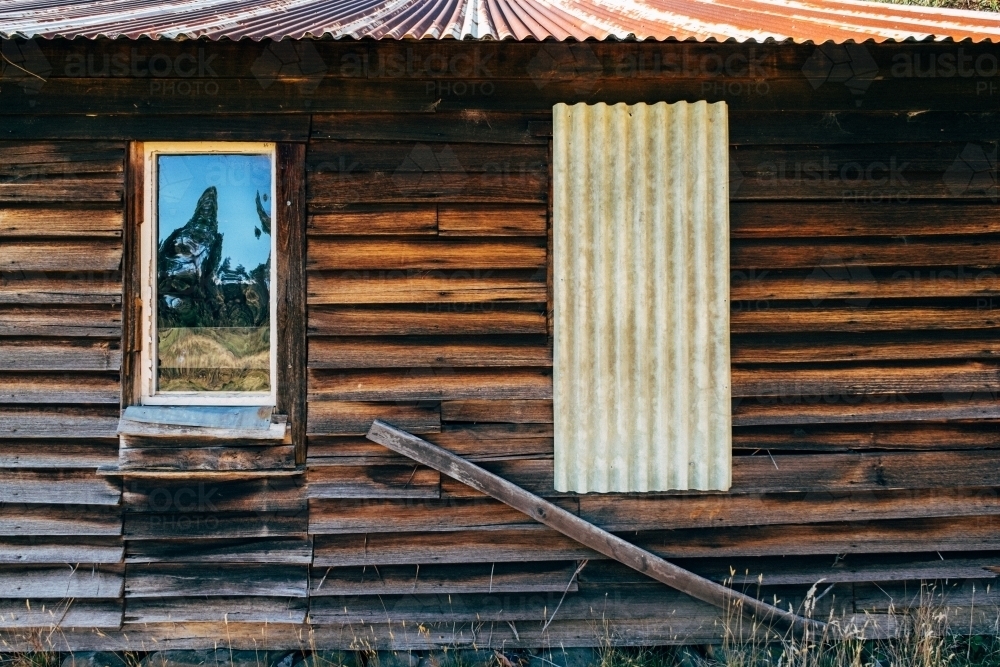 Image of Side of a brown weatherboard hut - Austockphoto