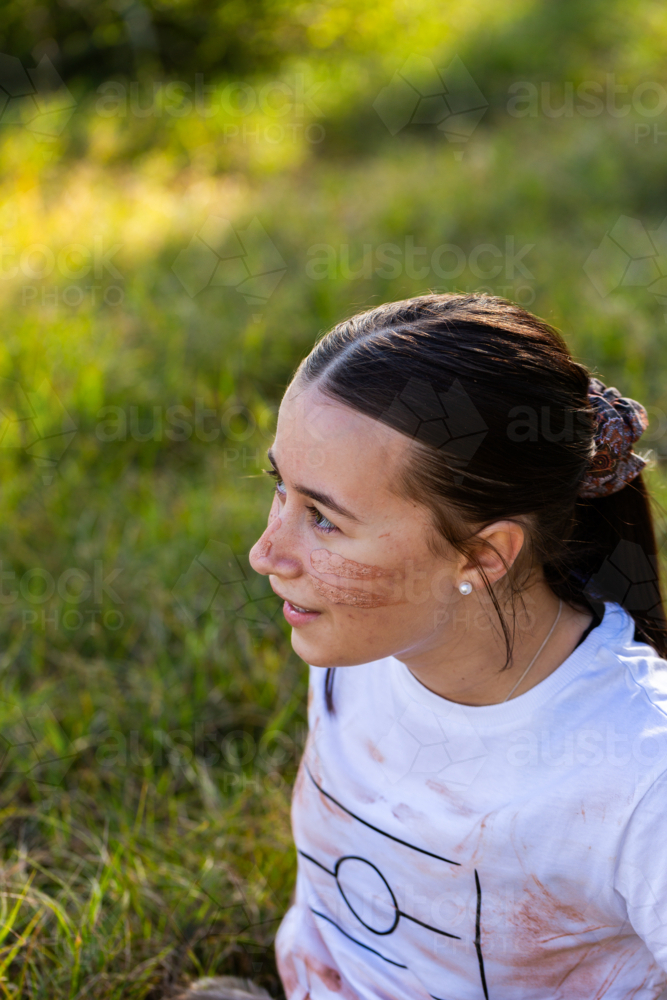 Image of Side profile of aboriginal kid wearing ochre face paint ...