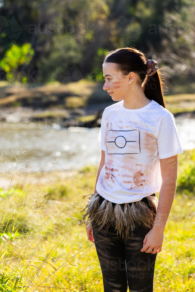 Image of Side profile of teen aboriginal kid outside by a river ...