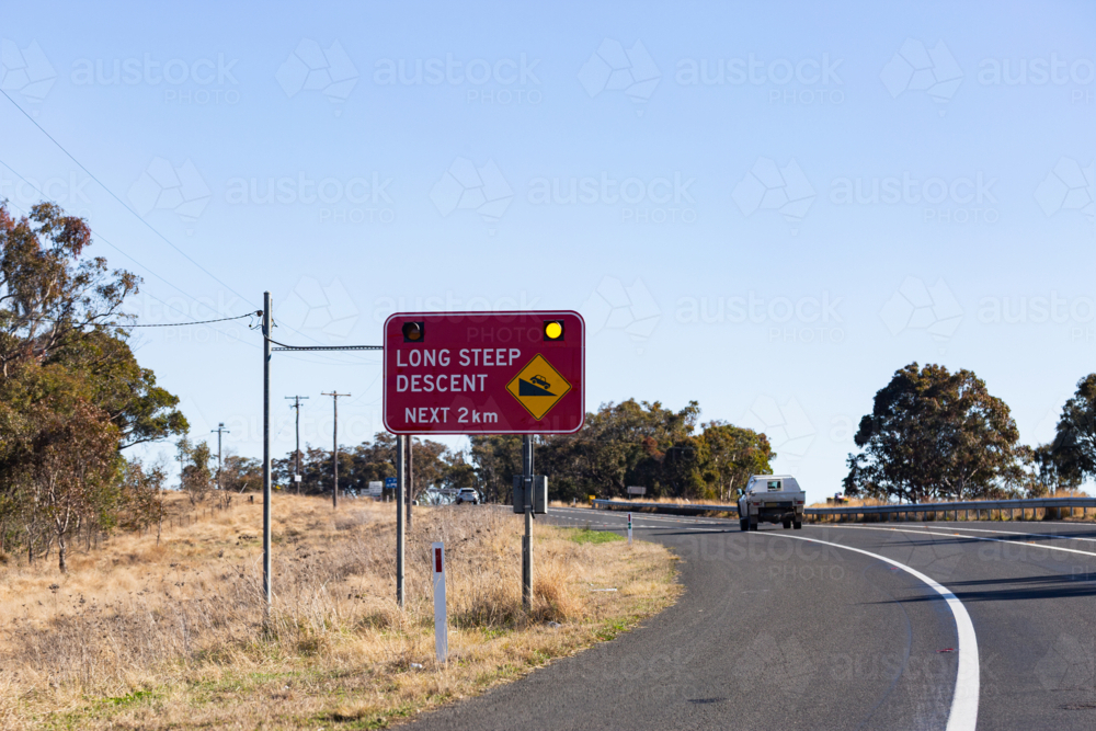 Image of sign warning of long steep descent ahead on highway road in ...