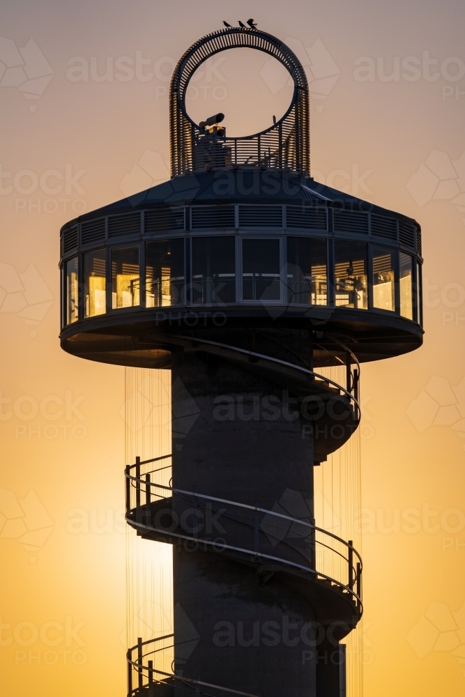 Image of Silhouette of a modern lookout tower against a golden dawn sky ...
