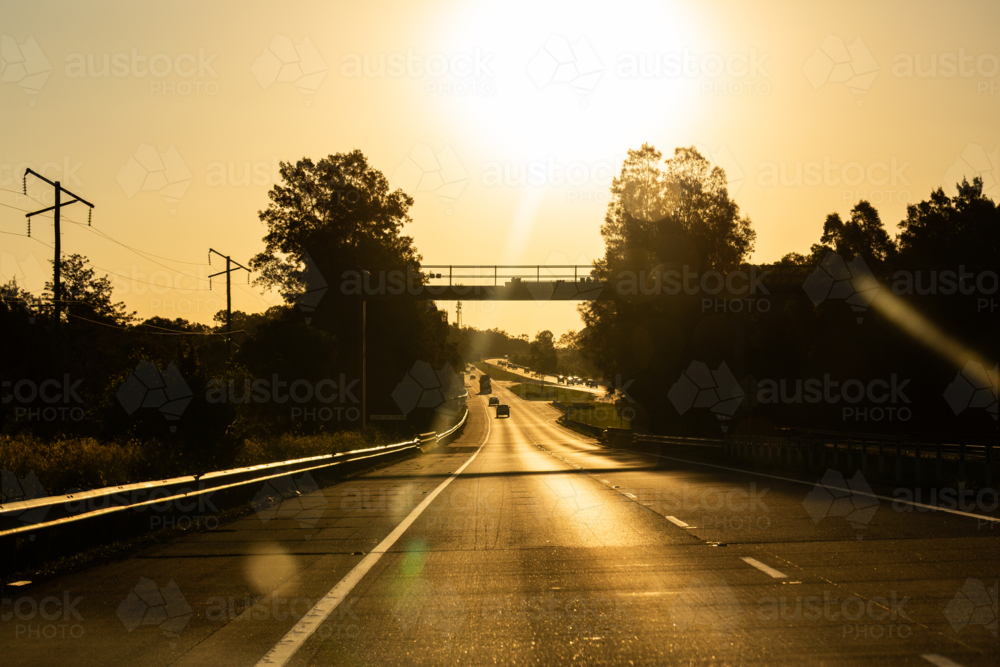 Image of Silhouette of trees beside M15 highway road in golden evening ...
