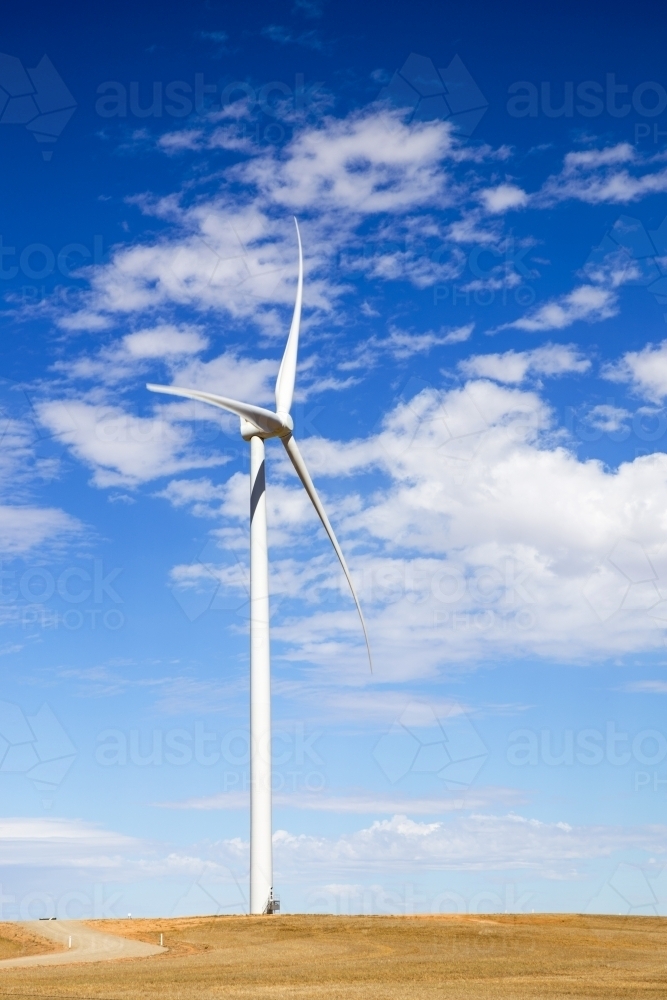 Image of Single wind turbine against blue sky with white clouds ...