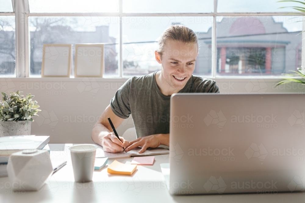 Image of Small business owner working at his desk in a bright office ...