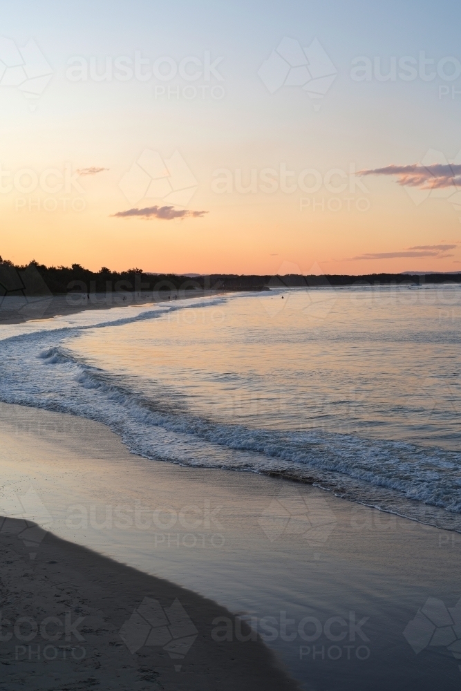 Image of Small waves on beach at sunset - Austockphoto