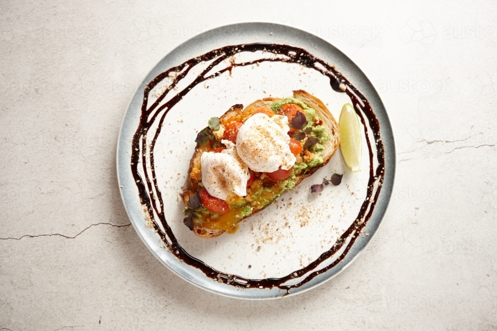 Image of Smashed avo on toast dish on table - Austockphoto