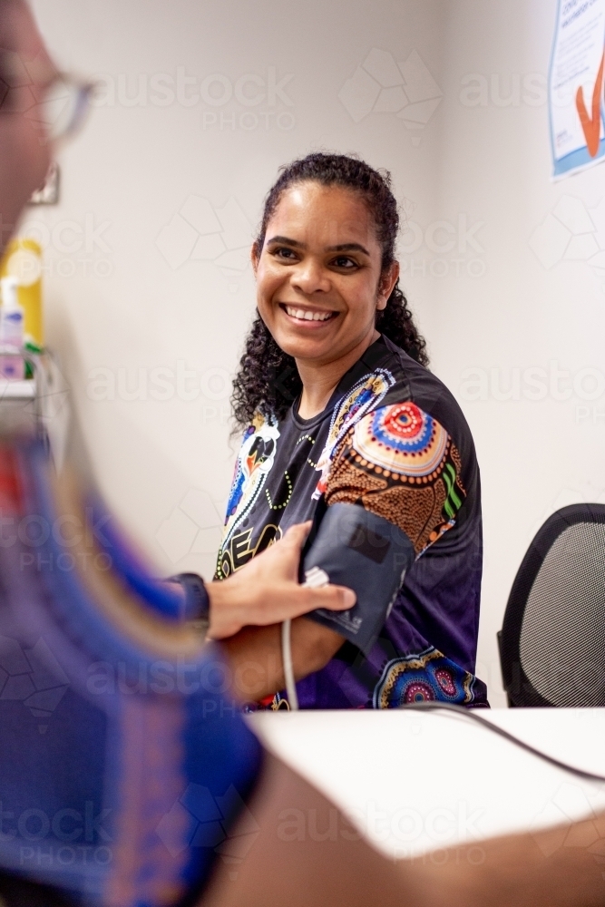 Image of Smiling Aboriginal woman in a medical consultation - Austockphoto