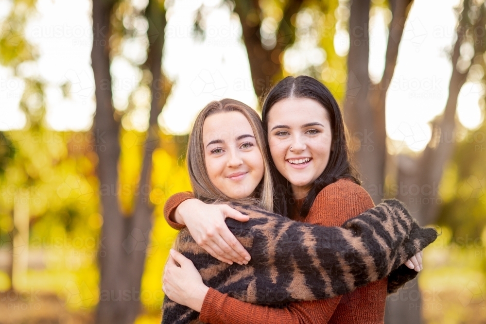Image of smiling best friends with arms around each other - Austockphoto