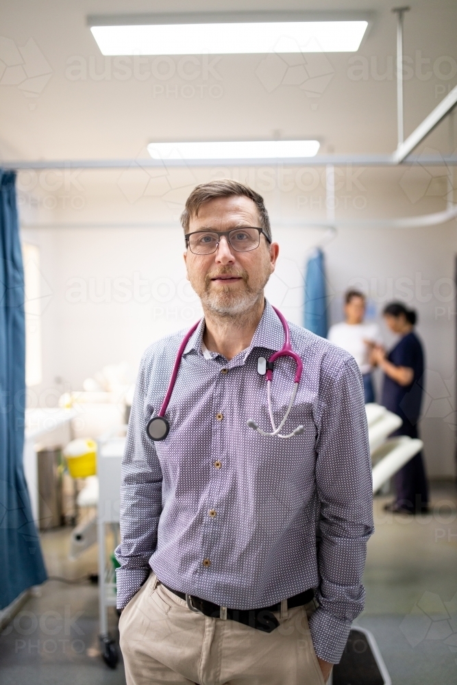 Image of Smiling middle-aged male doctor with a stethoscope around his ...