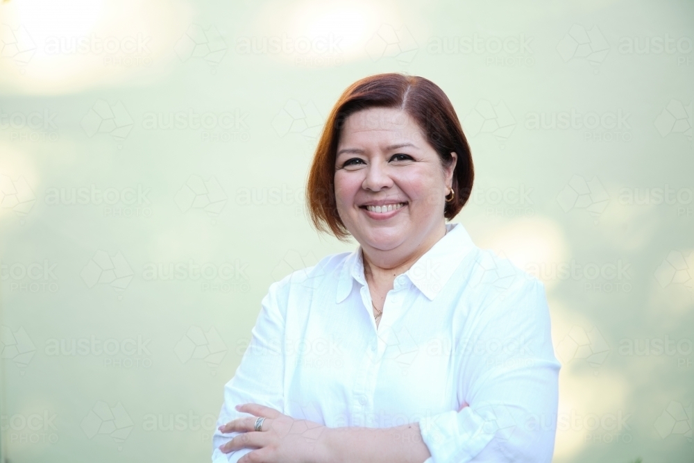 Image of Smiling middle aged woman with short hair wearing white shirt ...