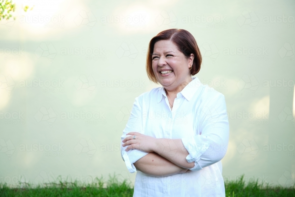 Image of Smiling middle aged woman with short hair wearing white shirt ...