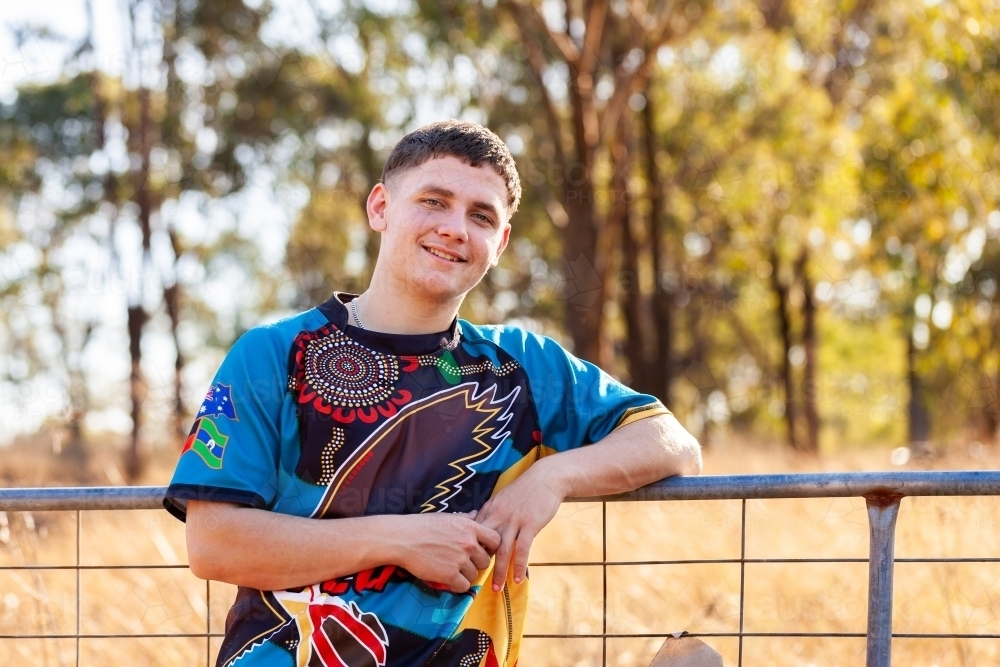 Image of Smiling portrait of 16yo aboriginal teen leaning on gate in ...