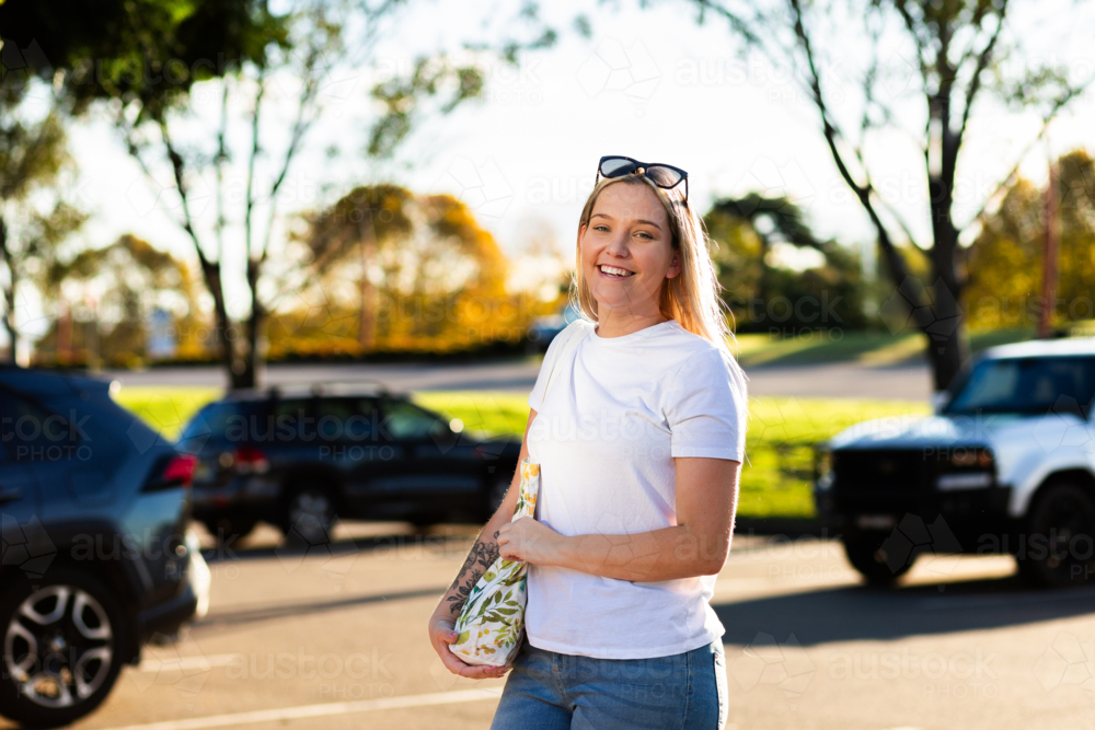 Image of Smiling portrait of backlit Aboriginal lady holding tote bag ...