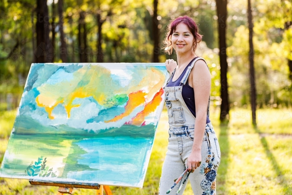Image of Smiling portrait of happy young woman artist in forest ...