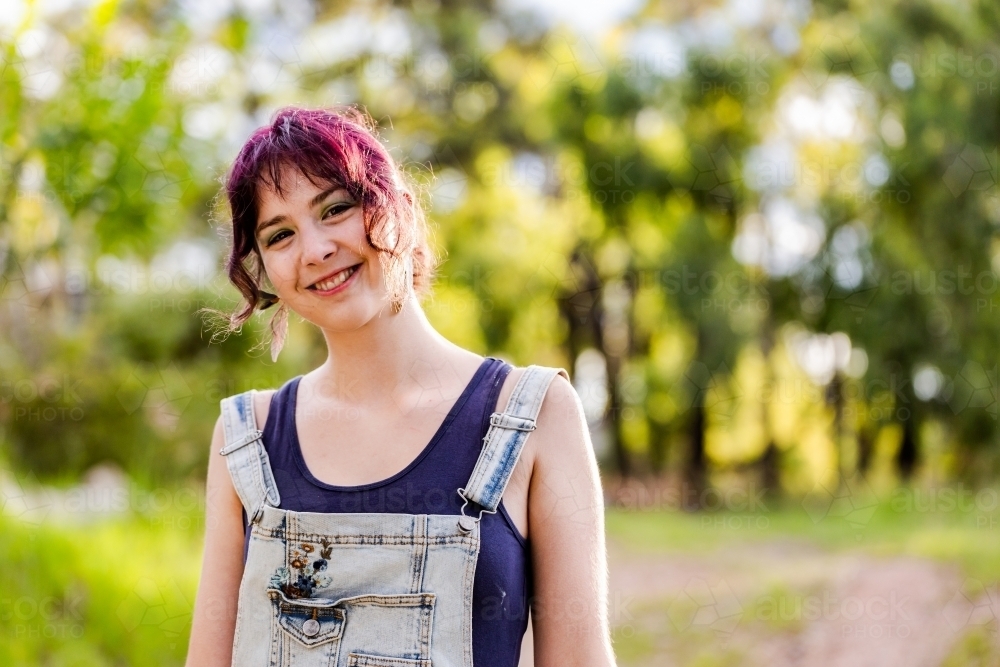Image of Smiling portrait of teenage young lady in overalls - Austockphoto
