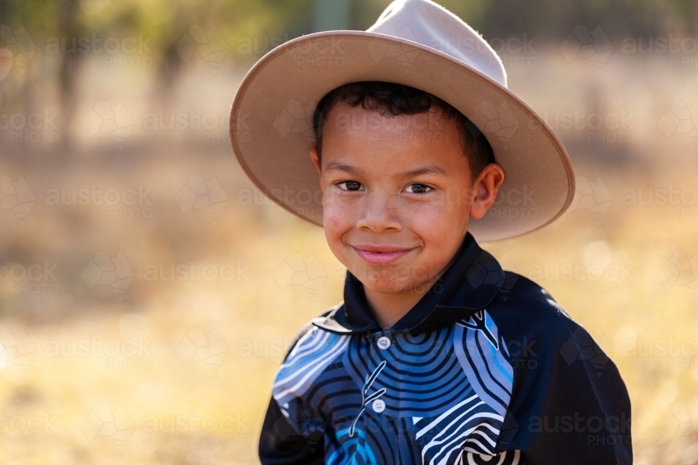 Image of Smiling portrait of young aboriginal boy wearing hat outside ...
