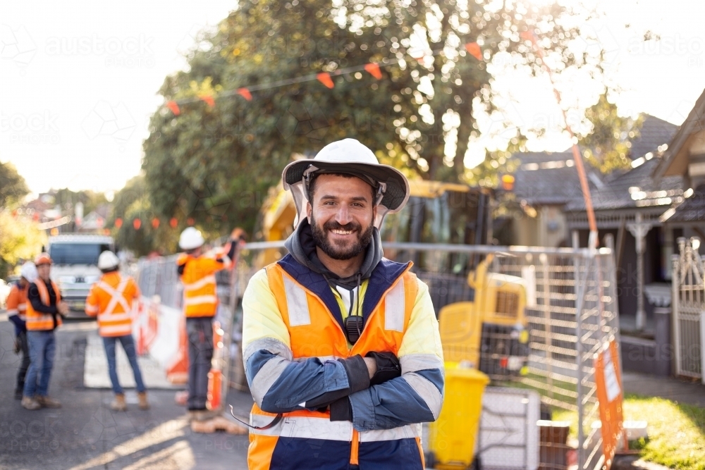 Image of Smiling road worker man with beard wearing orange and yellow ...