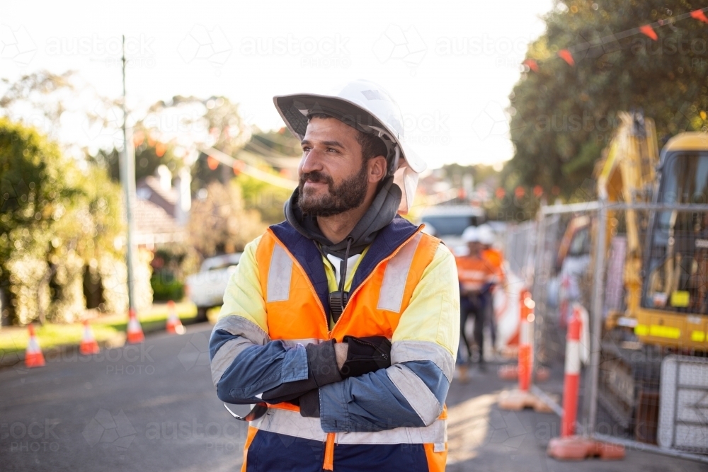 Image of Smiling road worker man with beard wearing orange and yellow ...
