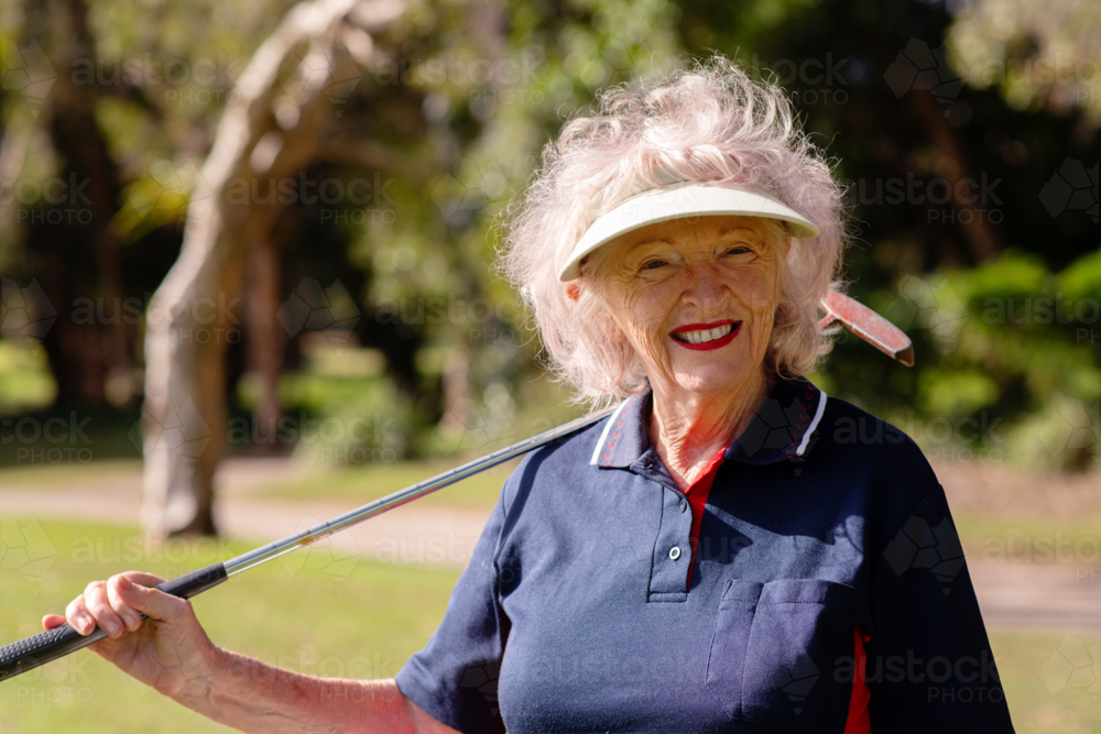 Image of smiling senior woman at golf - Austockphoto