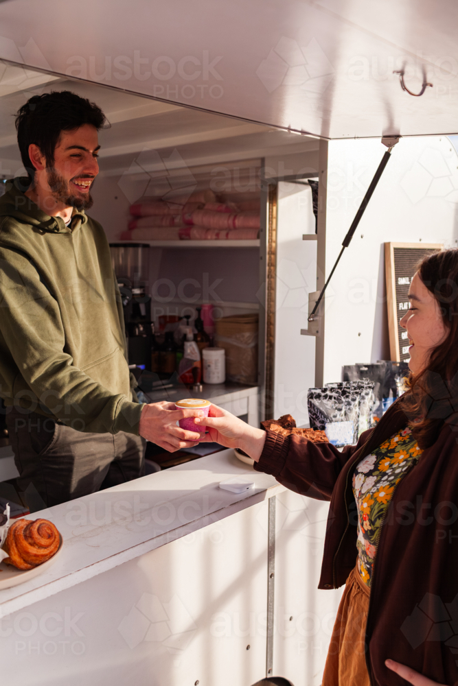 Image of smiling young Aussie barista man handing customer cup from ...