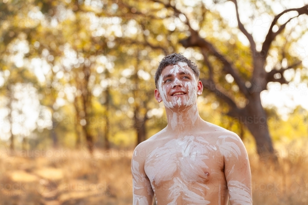 Image of Smiling young first nations Australian man looking up with ...