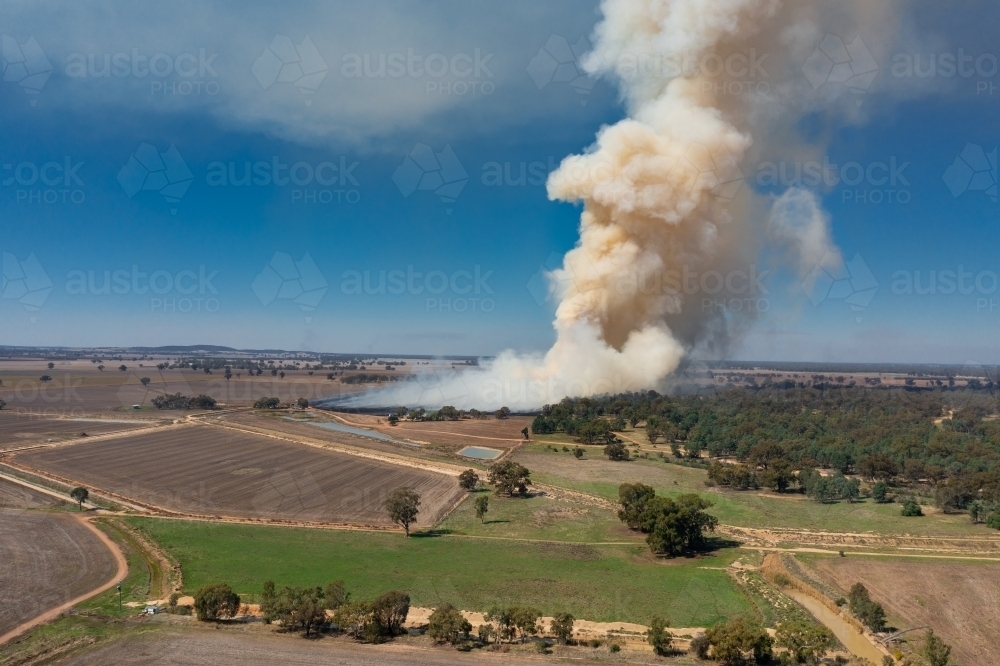 Image of Smoke billowing into the air from a bush fire over dry ...