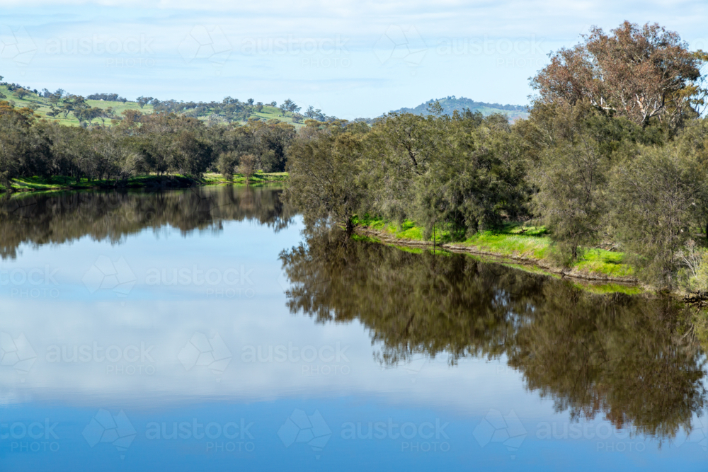 Image of Smooth calm river section with reflections - Austockphoto