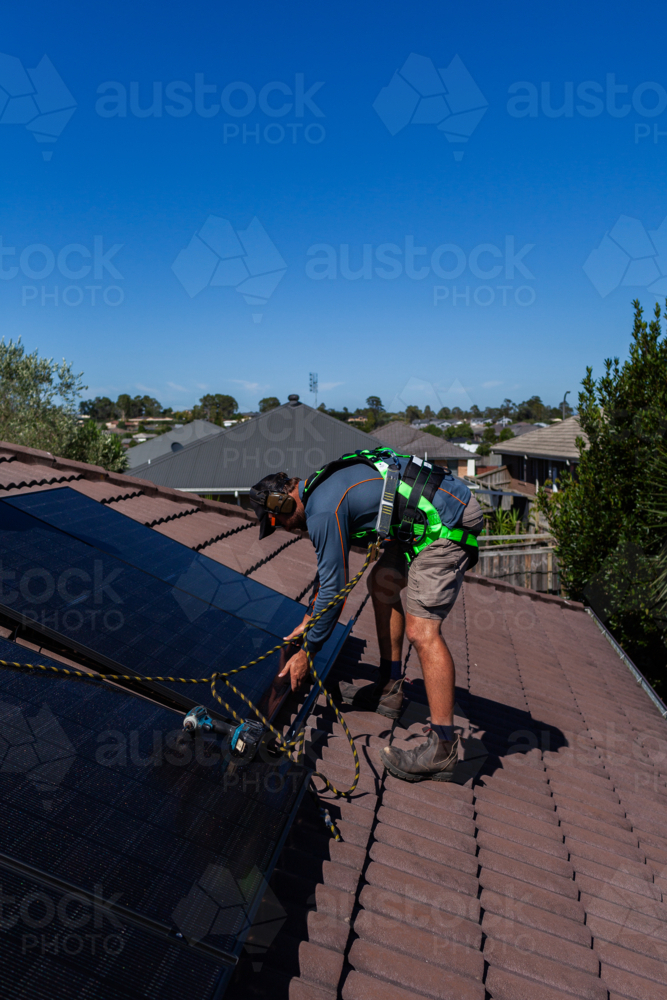 Image of Solar panel technician with drill installing solar panels on ...
